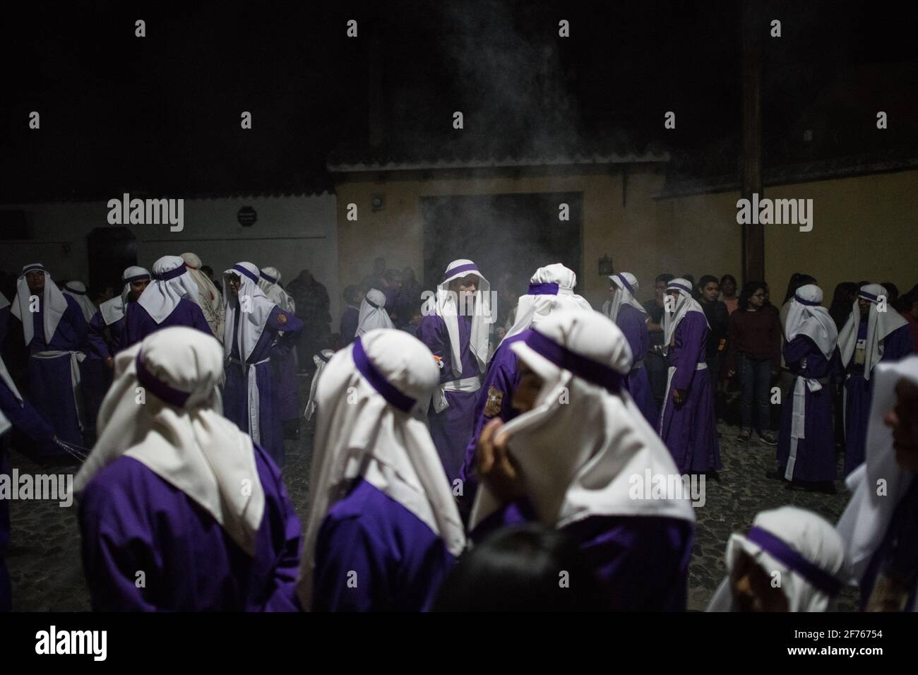 Cucuruchos in purple robes process solemnly through the streets of ...