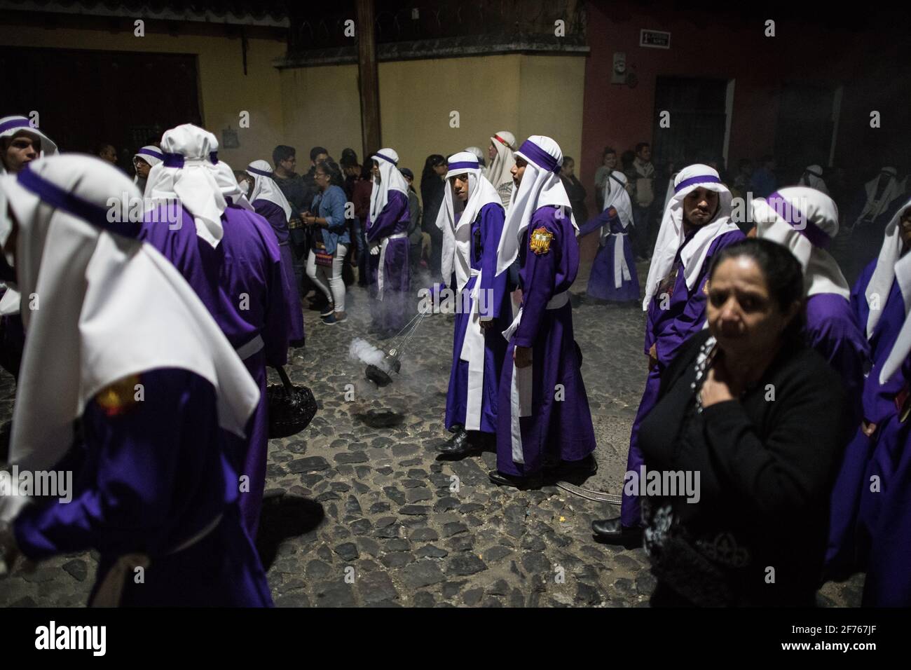 Cucuruchos in purple robes process solemnly through the streets of ...