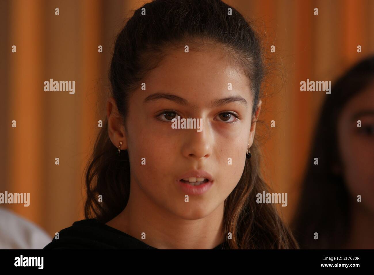 Portrait of cute teenage girl with serious and concentrated expression ...