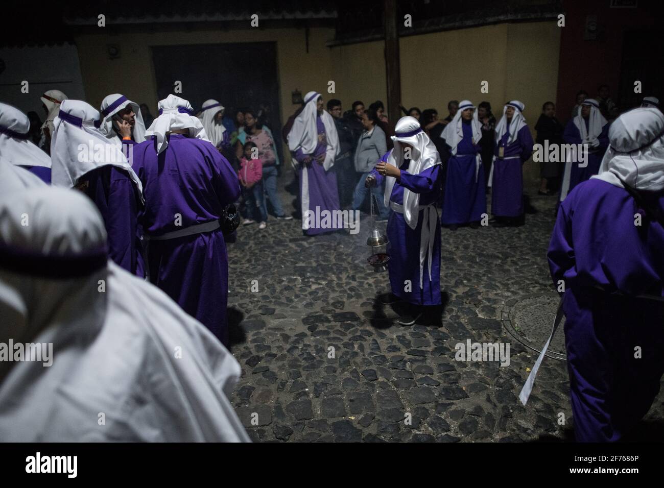 Cucuruchos in purple robes process solemnly through the streets of ...