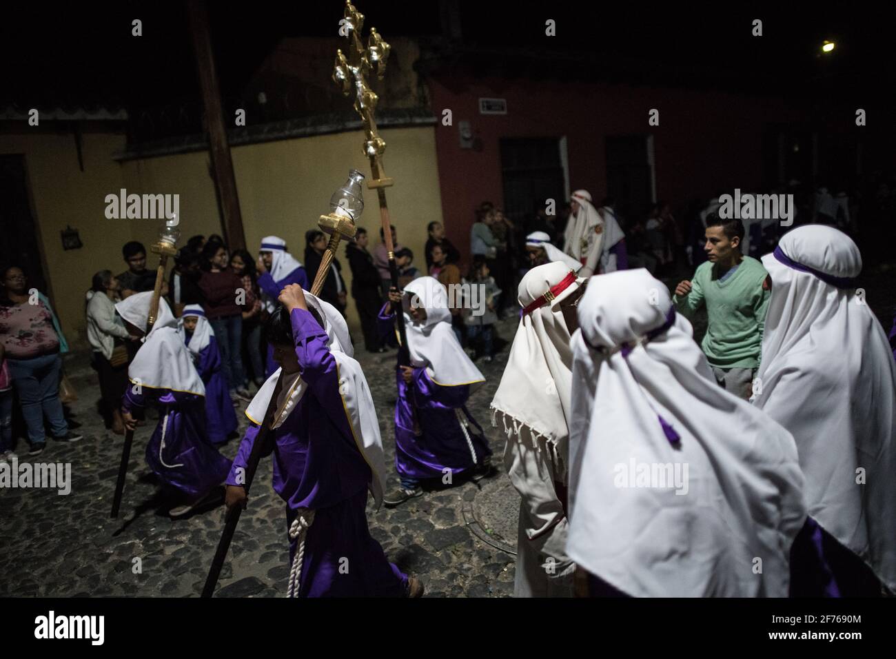 Cucuruchos in purple robes process solemnly through the streets of ...