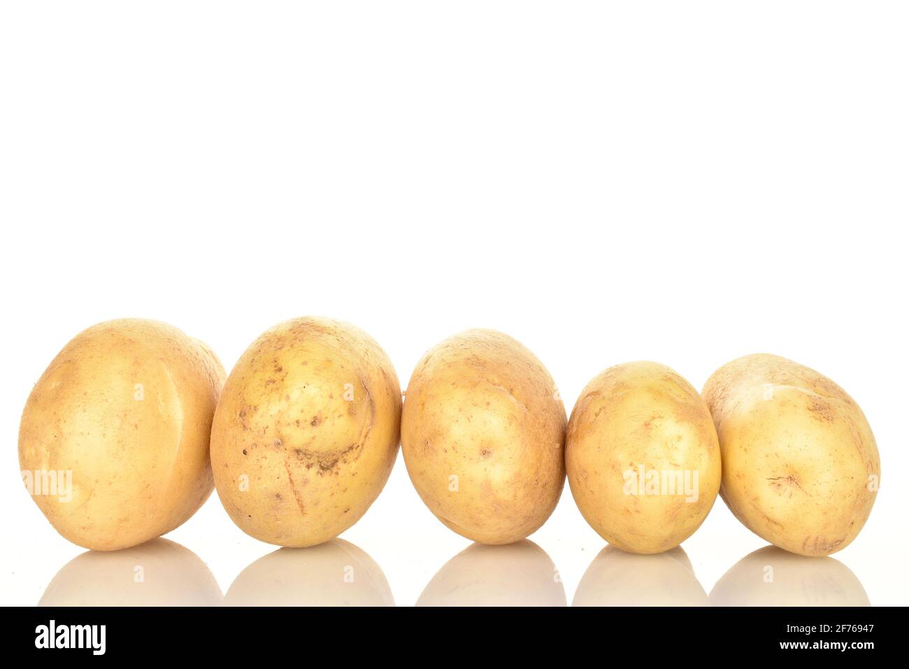 Several fresh, not peeled, uncooked, organic, juicy potatoes on a white ...