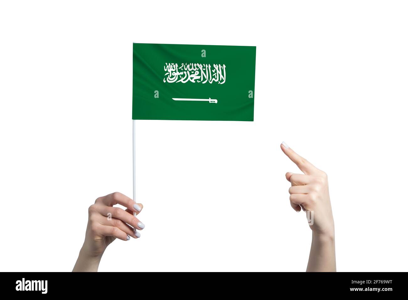 A beautiful female hand holds a Saudi Arabia flag to which she shows ...