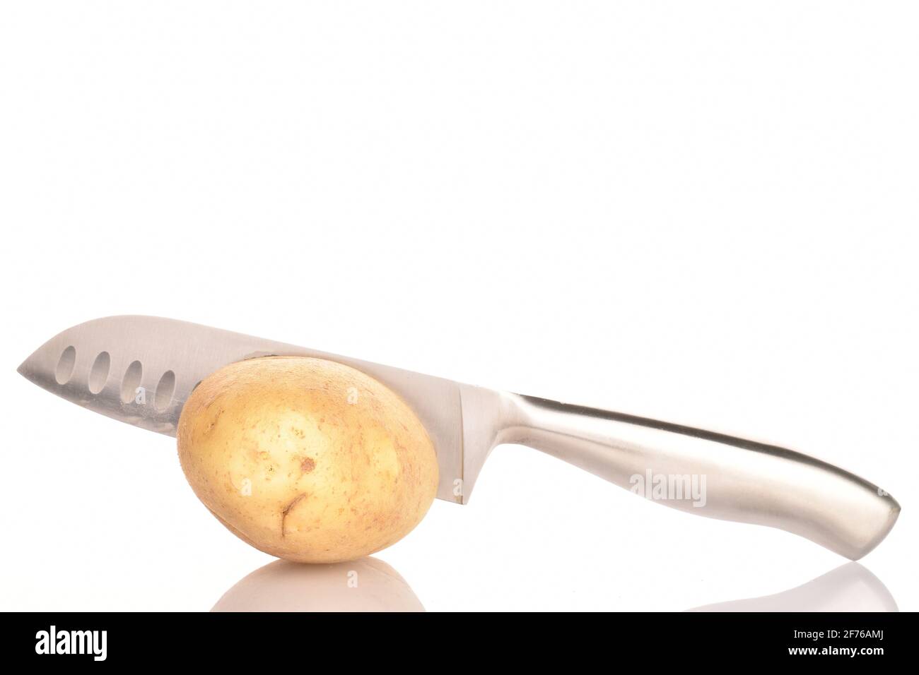 One fresh, not peeled, raw, organic, juicy potato with a metal knife ...
