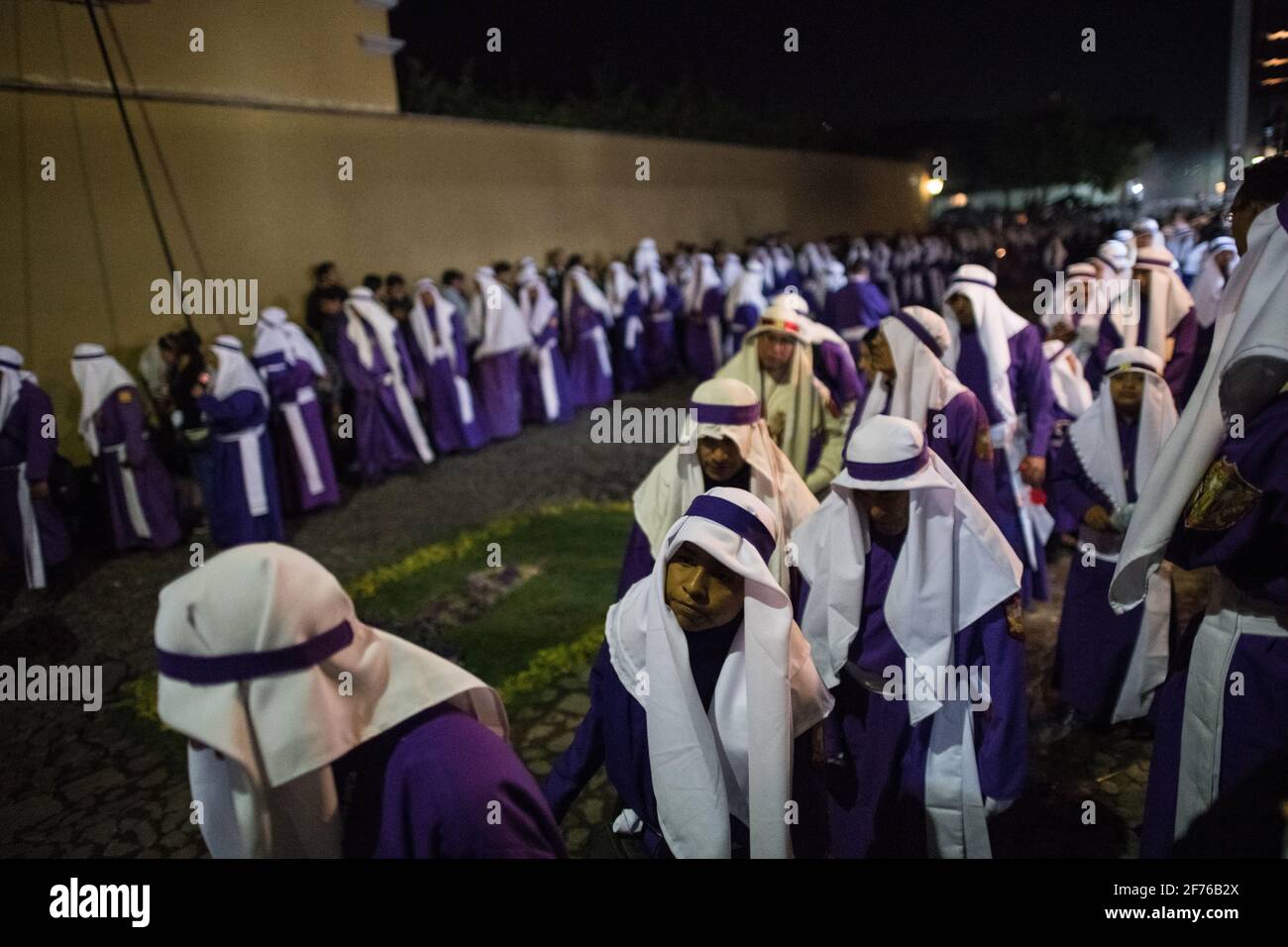 Cucuruchos in purple robes process solemnly through the streets of ...