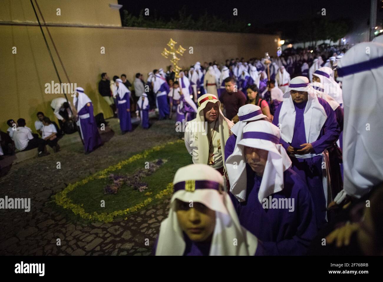 Cucuruchos in purple robes process solemnly through the streets of ...