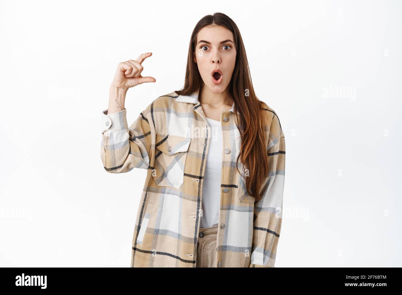 Surprised and impressed woman holding small little thing, hand tiny ...