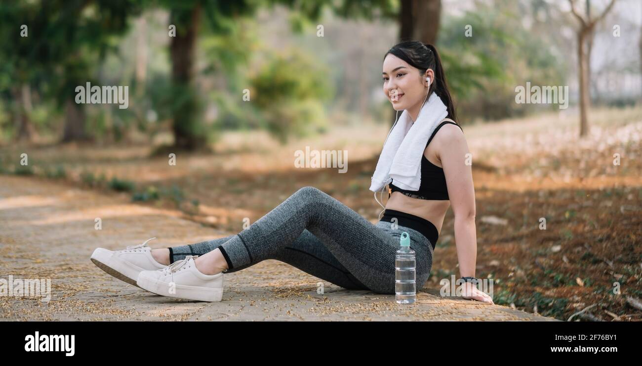 Athletic asian woman resting after a hard training in the mountains at ...