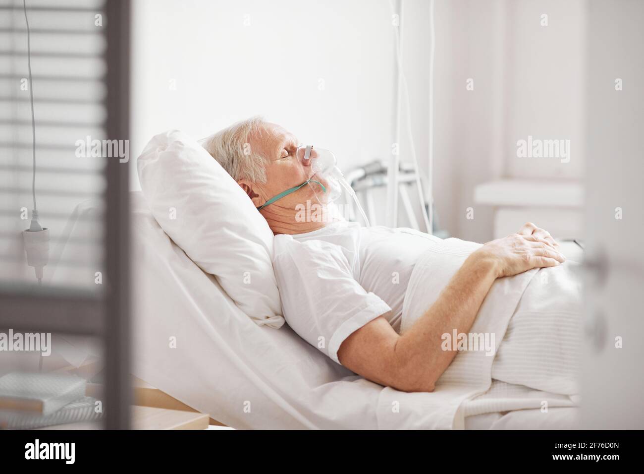 Side view at ill senior man lying in hospital bed with oxygen ...