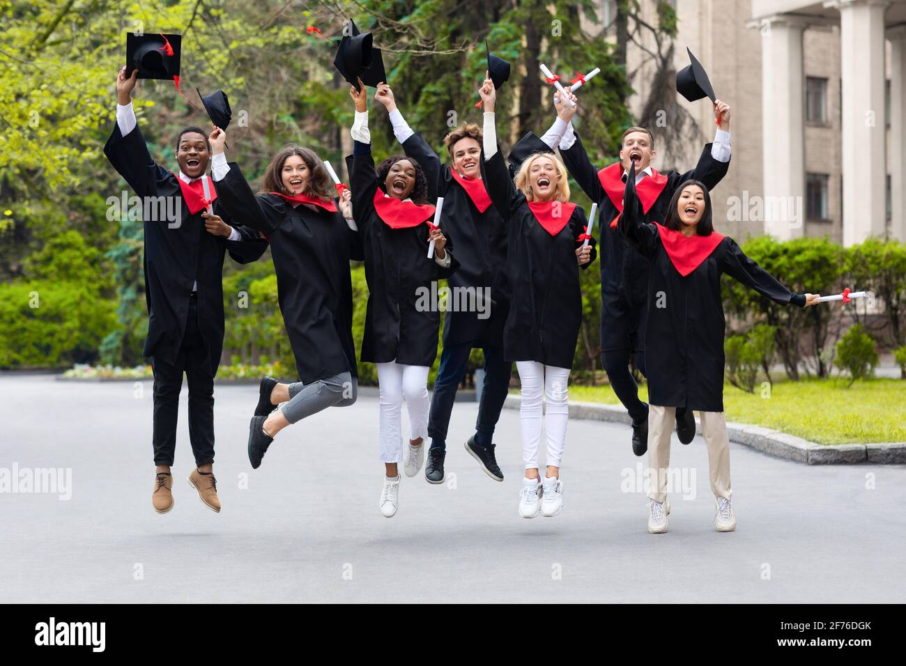 Happy students celebrating graduation from university, jumping up Stock ...
