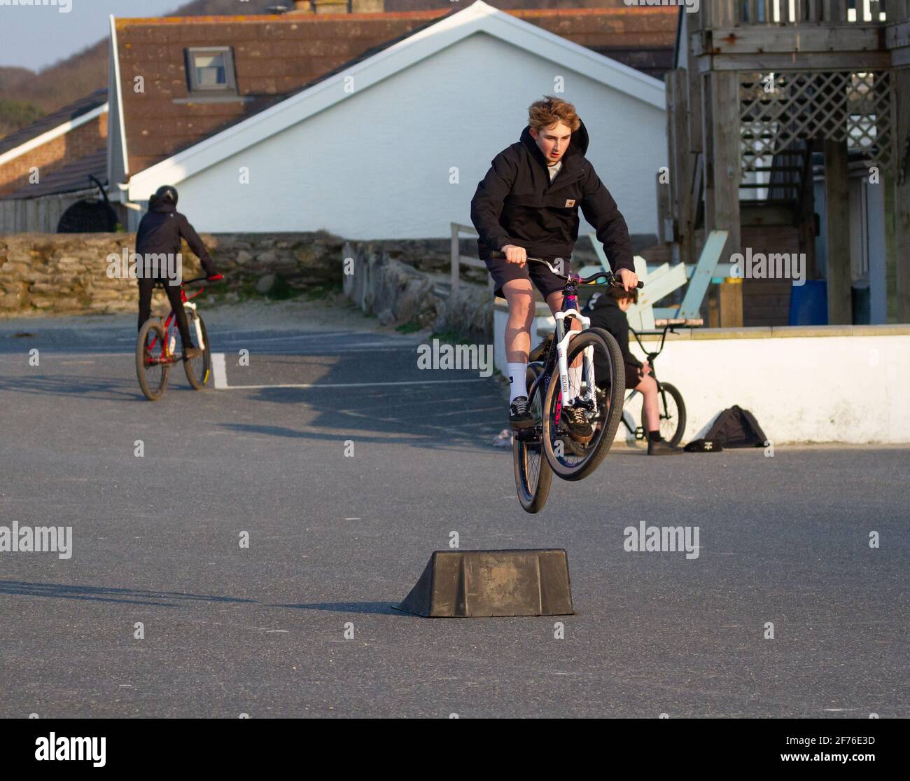 Young Lads practice their stunt skills on BMX bikes in a deserted car ...