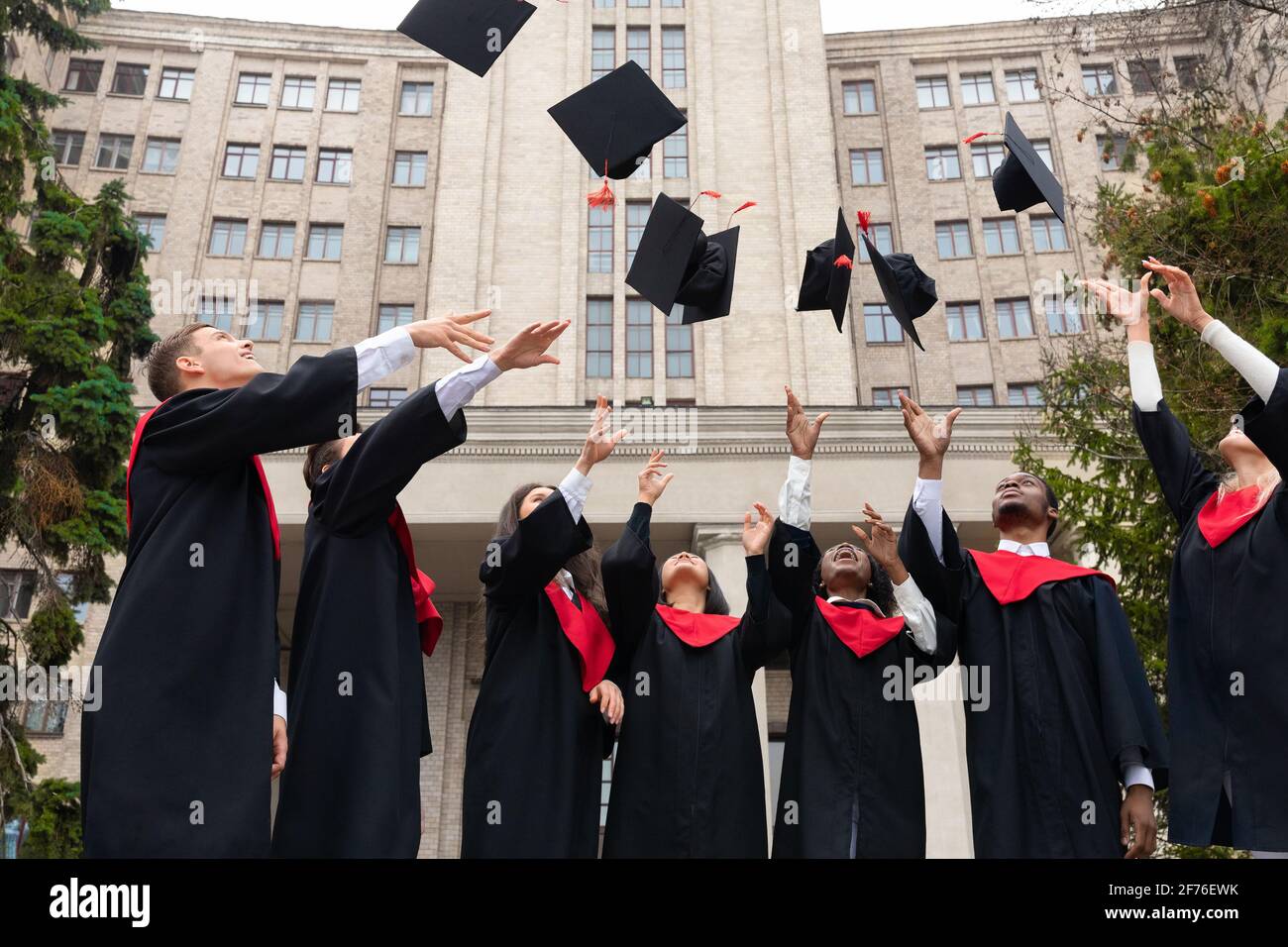 International group of students throwing graduation caps up Stock Photo ...
