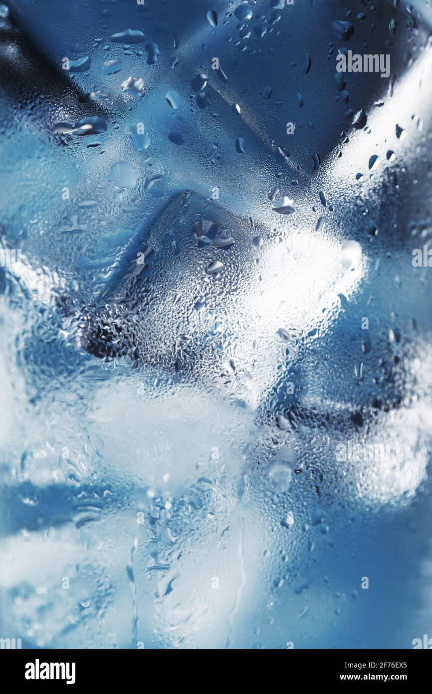 Ice cubes in a misted glass with drops of ice water close-up macro. Refreshing and chilling ...