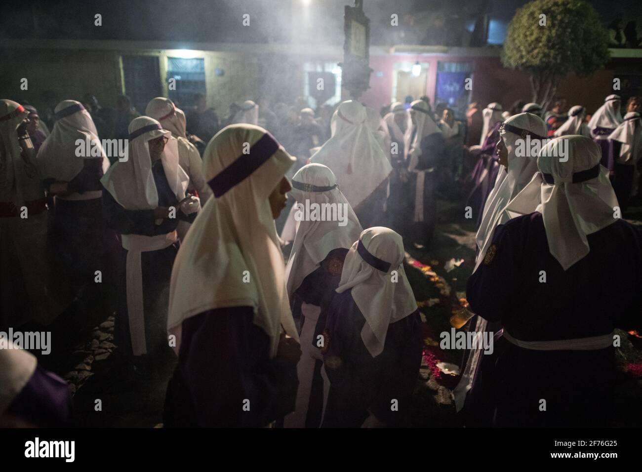 Cucuruchos in purple robes process solemnly through the streets of ...