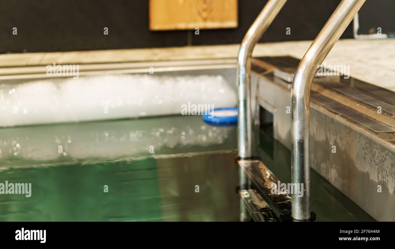 Ladder with handrails leading to the pool with ice cold water for body ...
