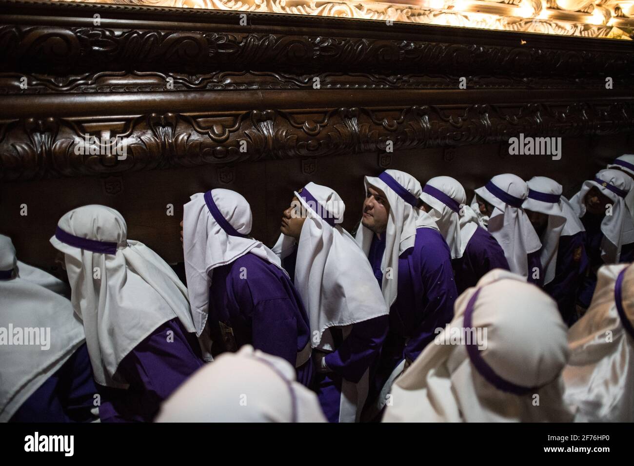 Cucuruchos in purple robes process solemnly through the streets of ...