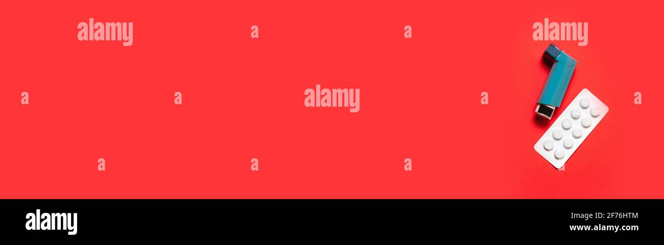 Asthma inhaler, pills and with copy space on red background, top view ...