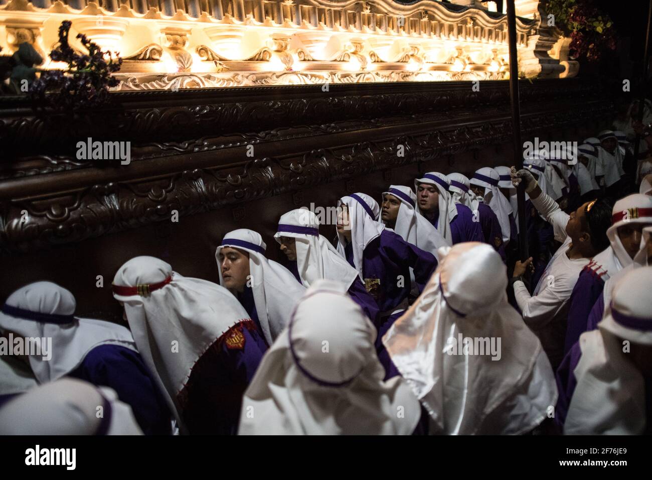 Cucuruchos in purple robes process solemnly through the streets of ...