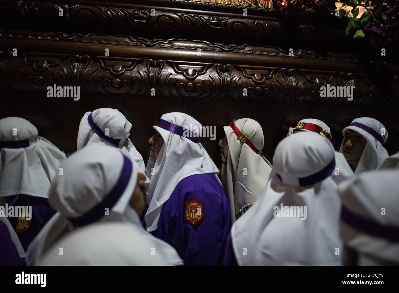 Cucuruchos in purple robes process solemnly through the streets of ...