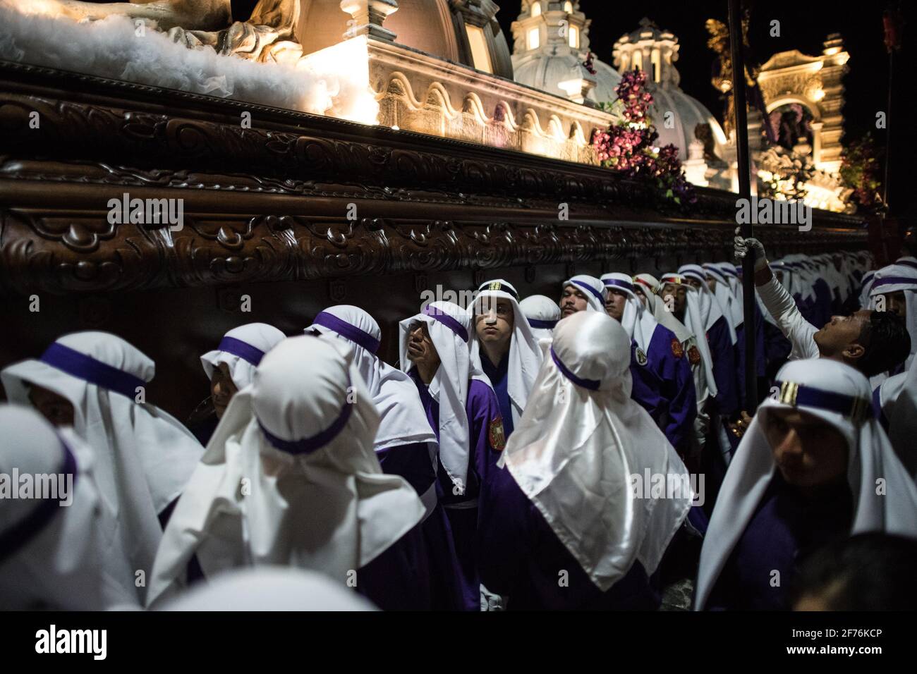 Cucuruchos in purple robes process solemnly through the streets of ...