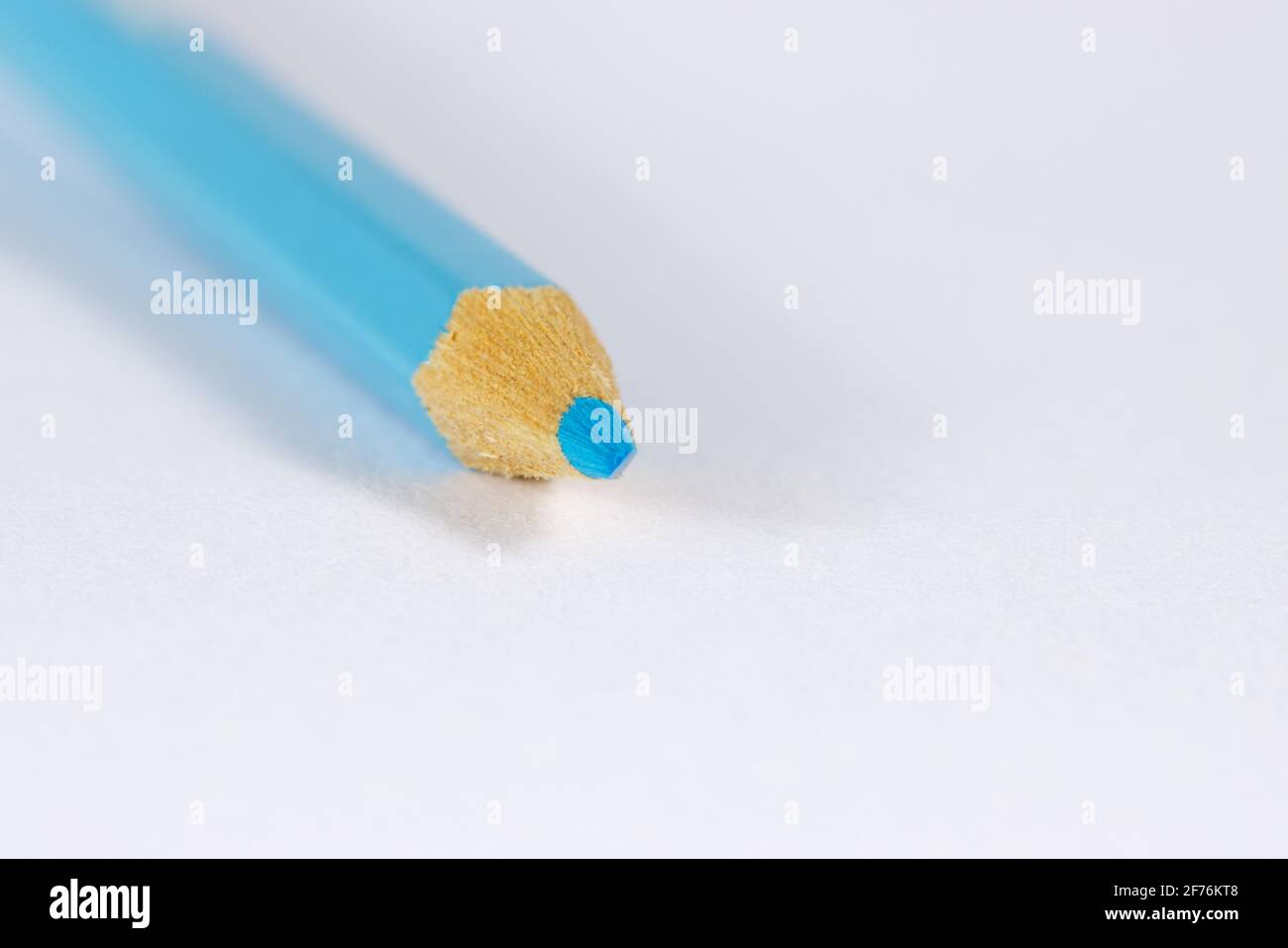 Light Blue sharpened pencil point to the left on a white background ...