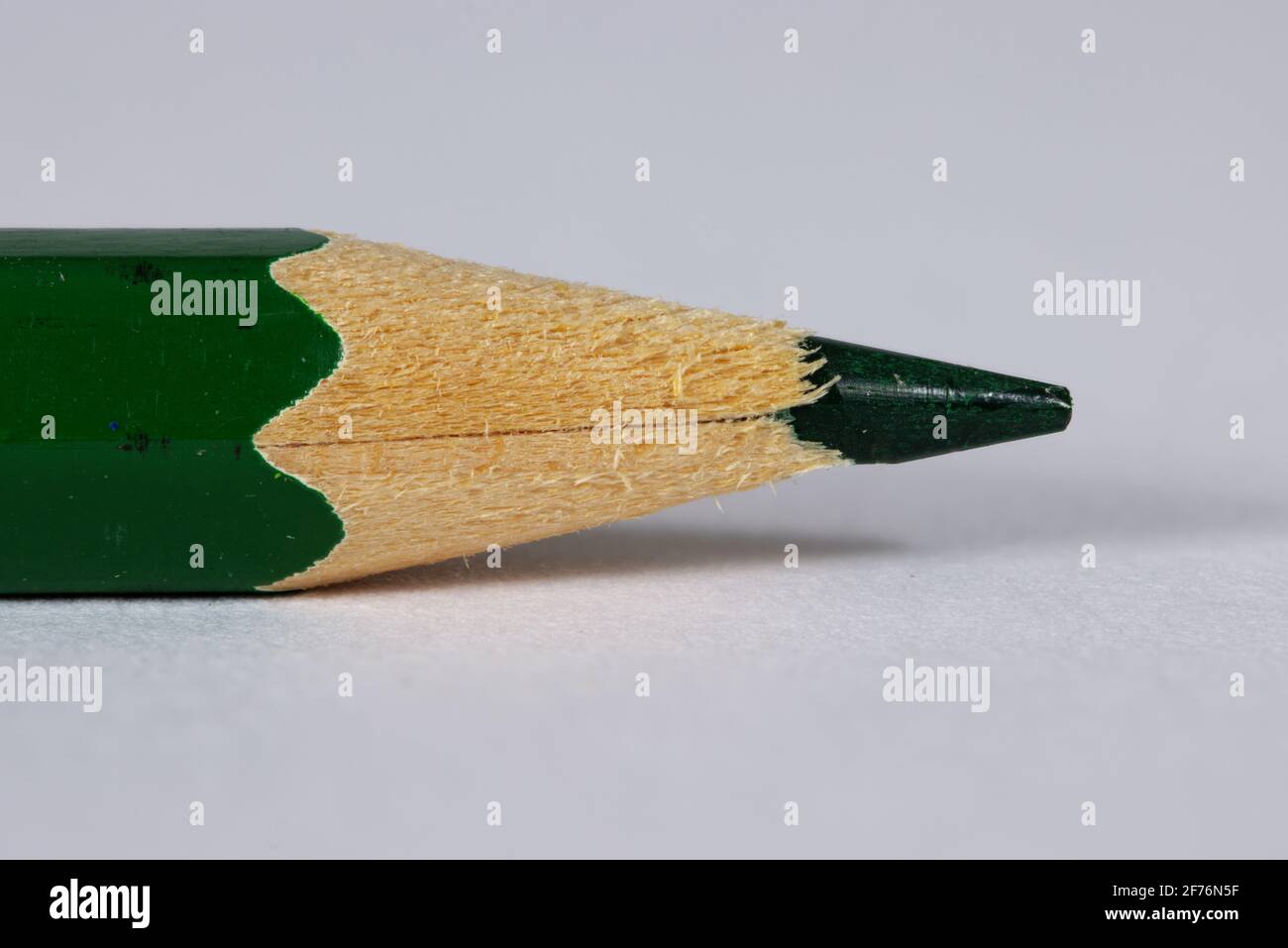 Dark Green sharpened pencil point to the left on a white background ...