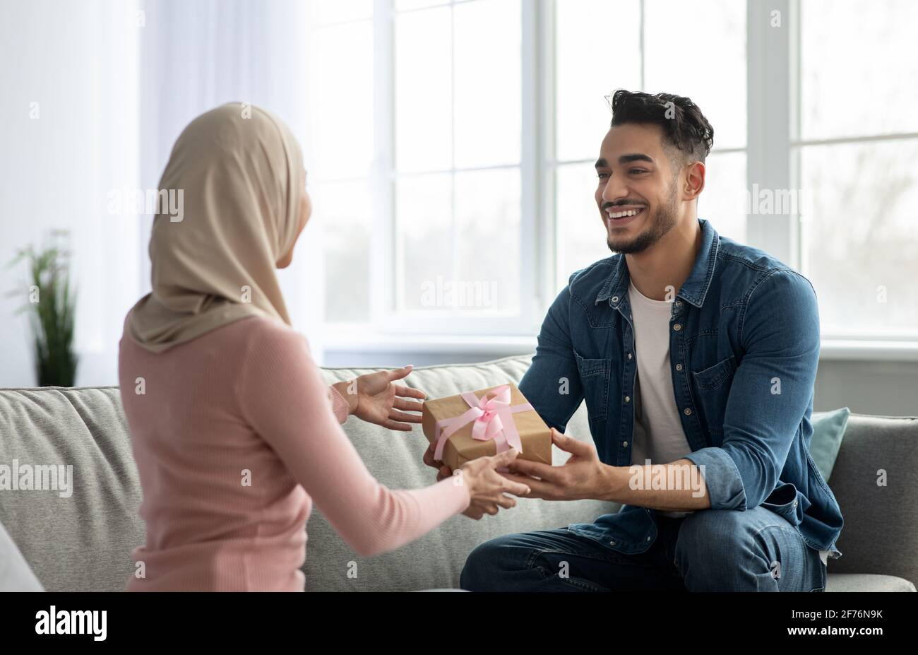 Handsome arab man giving gift box his wife Stock Photo - Alamy