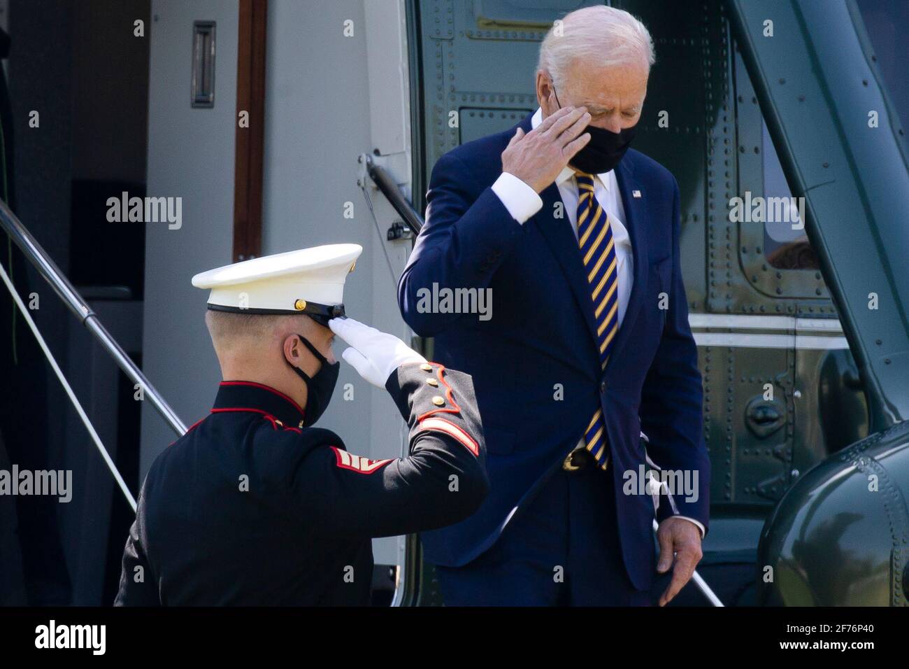 US President Joe Biden salutes a US Marine as he walks off Marine One ...