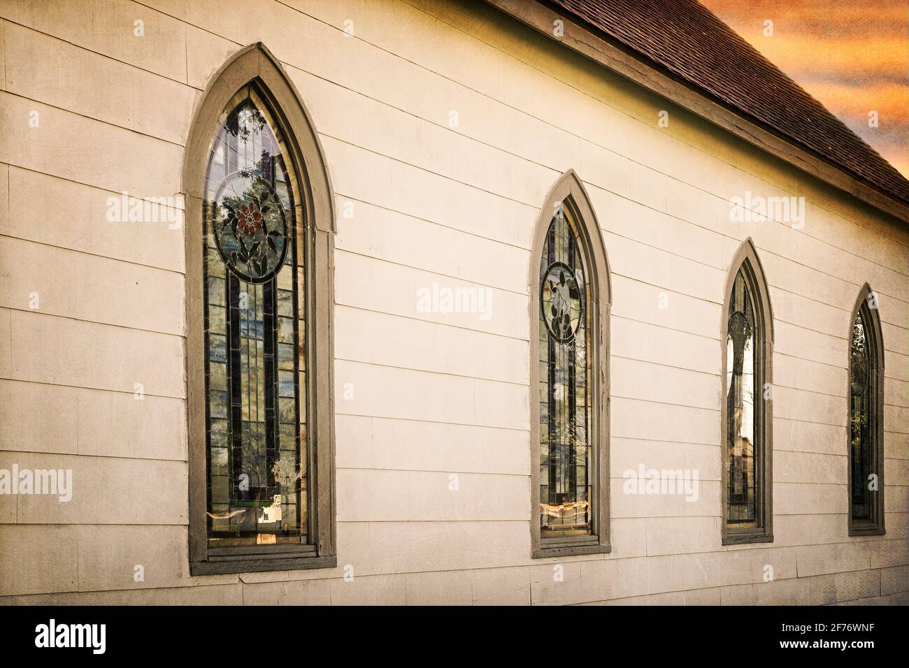 Photograph of the side of a church with stained glass windows and a ...