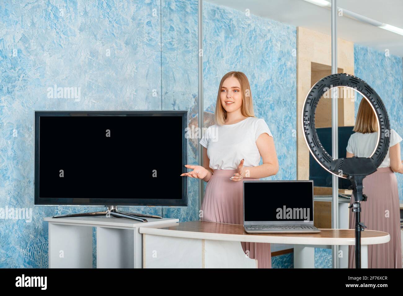 Young beautiful woman making presentation with monitor and laptop empty ...
