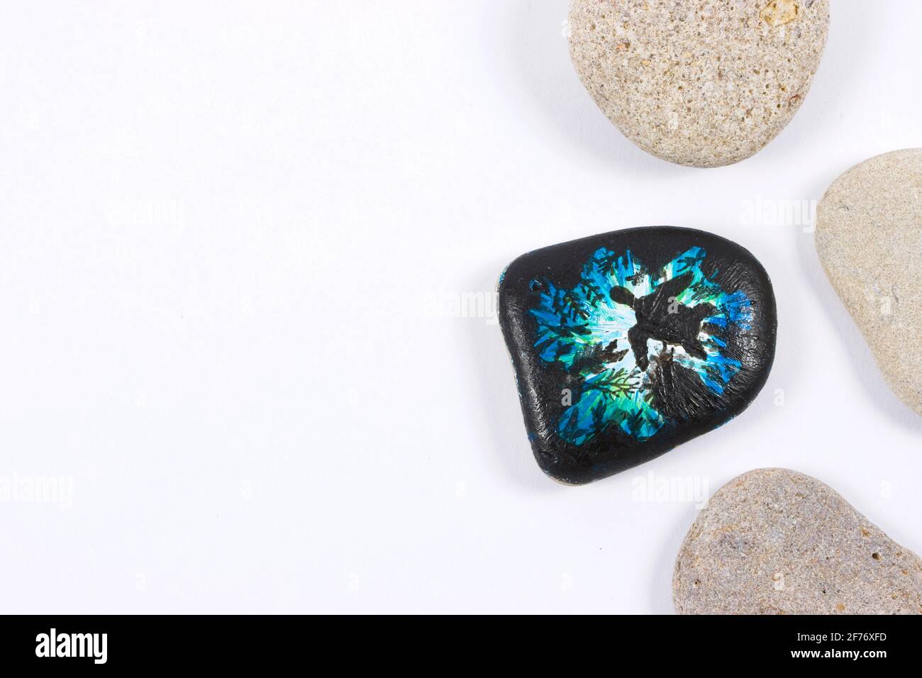 Painted Pebbles on a white background of a sea turtle with copy space ...