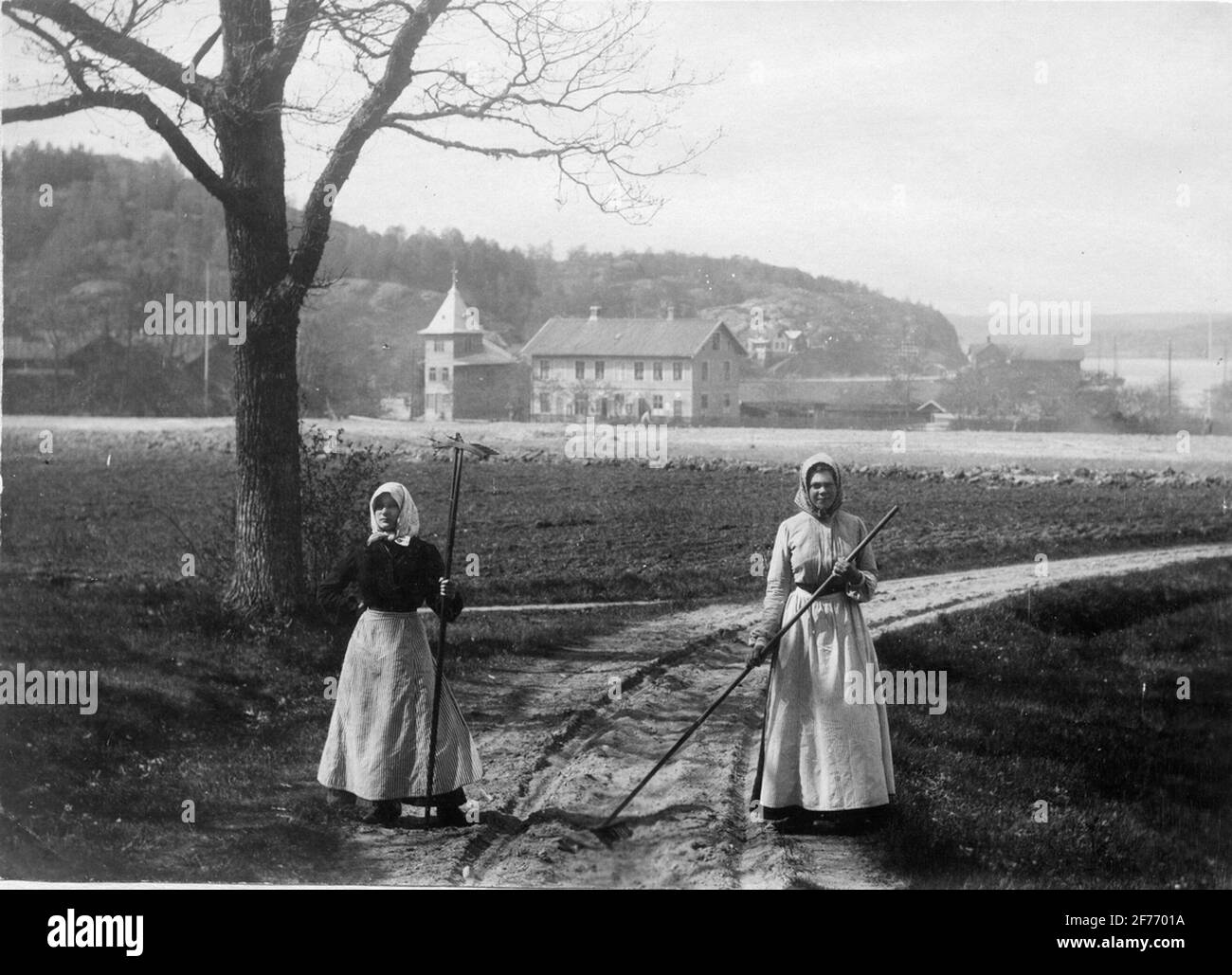 Two women with rails on gravel road leading towards heatherskila harbor ...