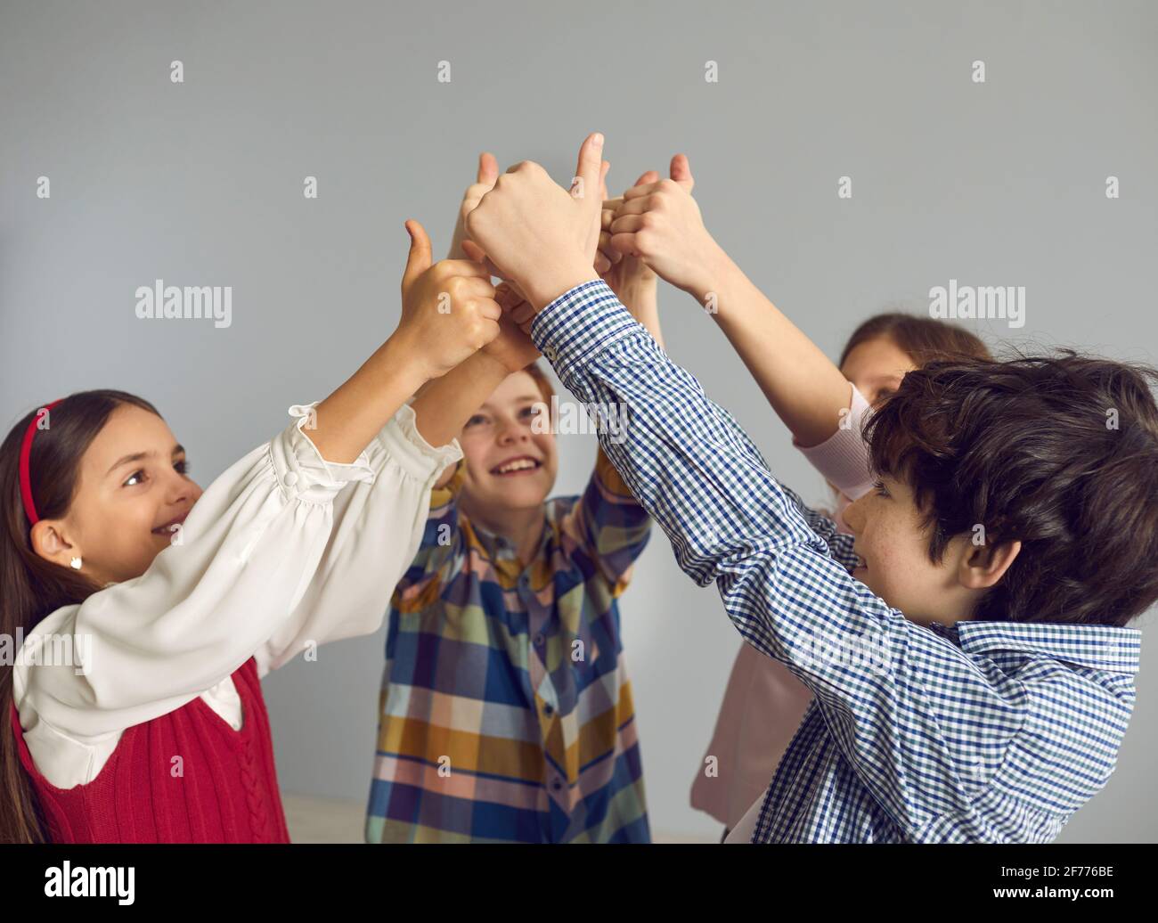 Group of positive little children give thumbs up as they join their ...