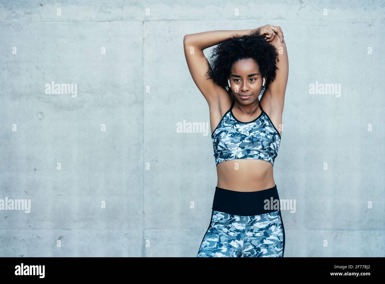 Afro athletic woman stretching arms before exercise Stock Photo - Alamy