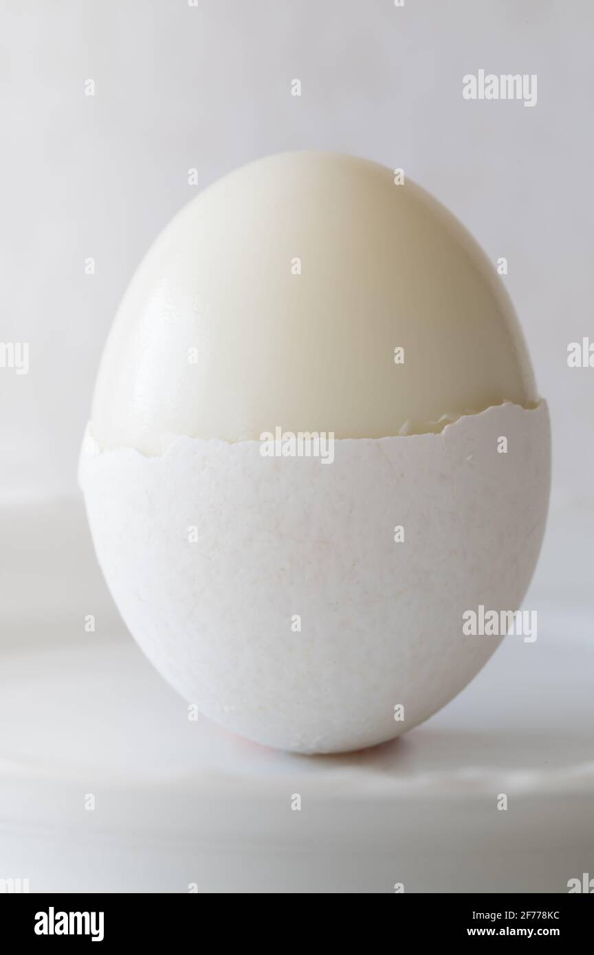 Hardboiled Egg with Half a Shell on White Background Stock Photo - Alamy