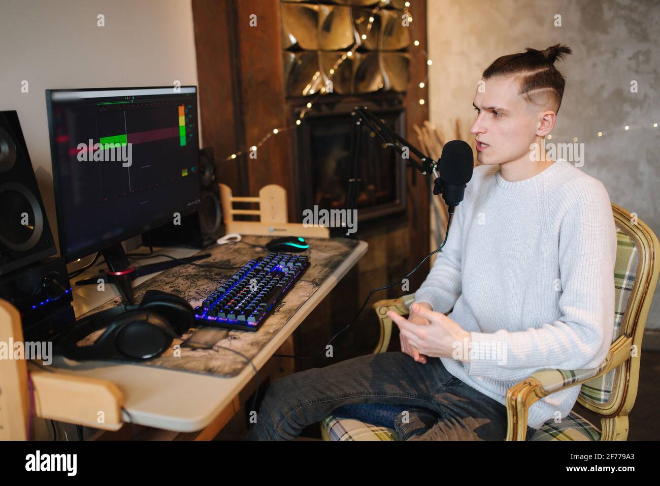 Young man makes a podcast audio recording at home. Man using pc and two ...