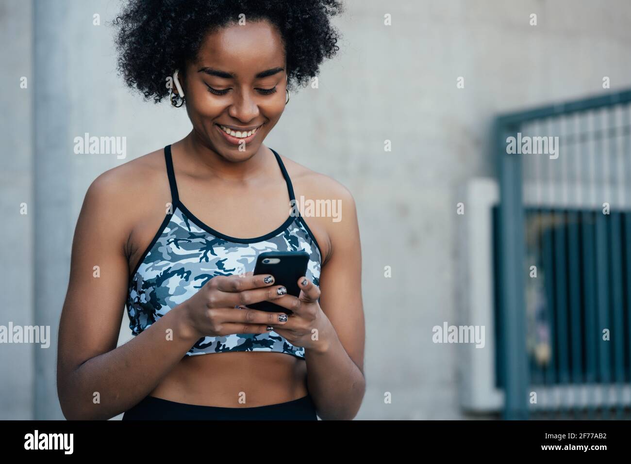 Athletic woman using her mobile phone outdoors Stock Photo - Alamy
