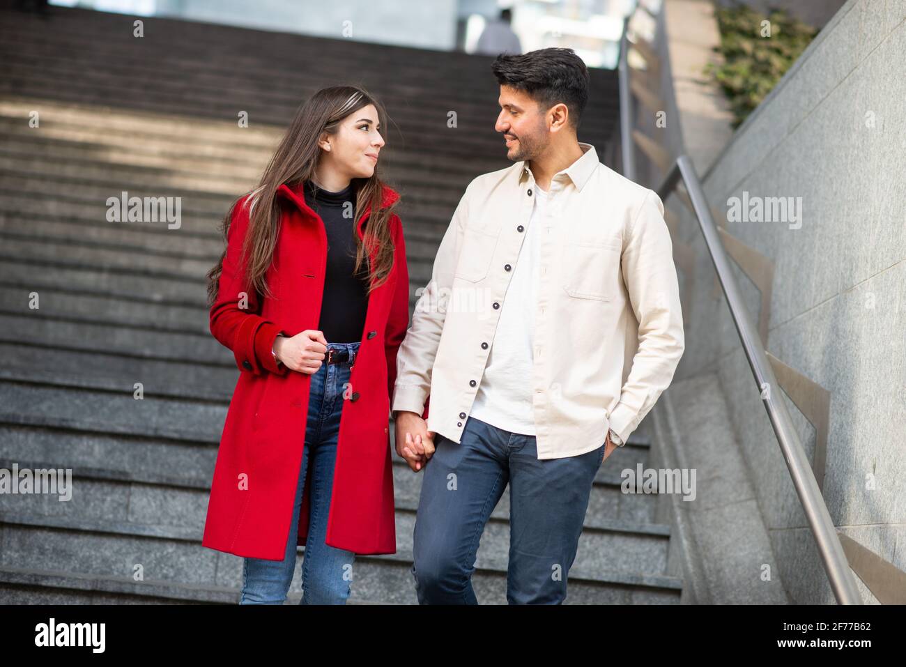 Happy couple walking down a staircase together Stock Photo - Alamy