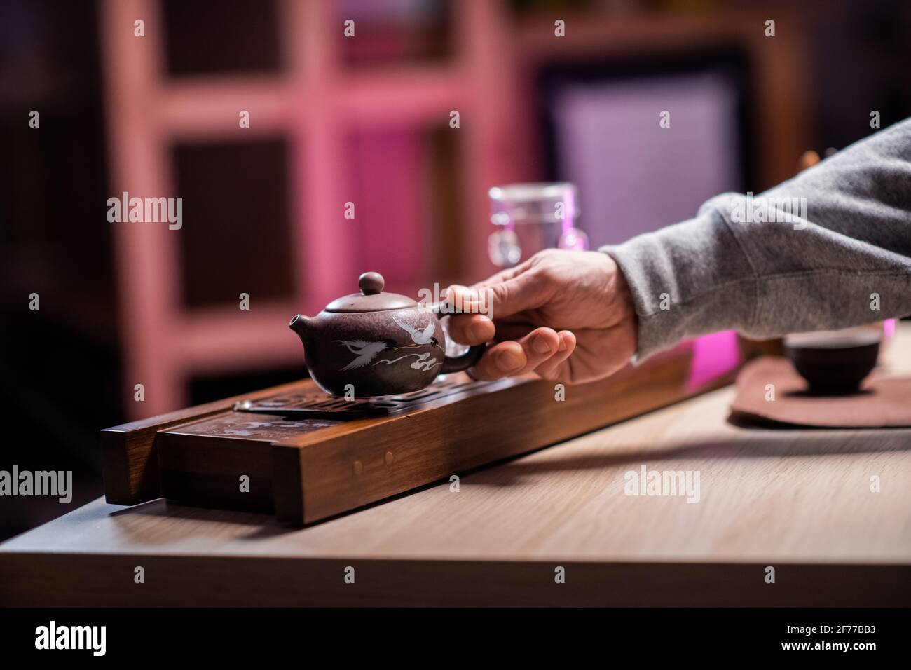 Close-up of a traditional ceramic teapot with hot aromatic tea filling ...