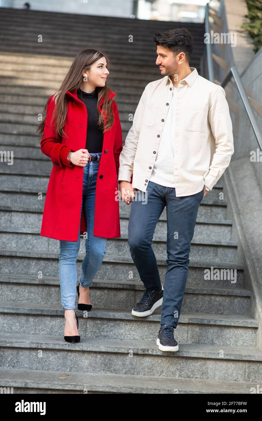 Happy couple walking down a staircase together Stock Photo - Alamy
