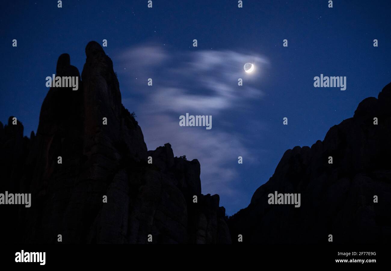 Crescent moon behind the silhouette of Sant Jeroni spires, in ...