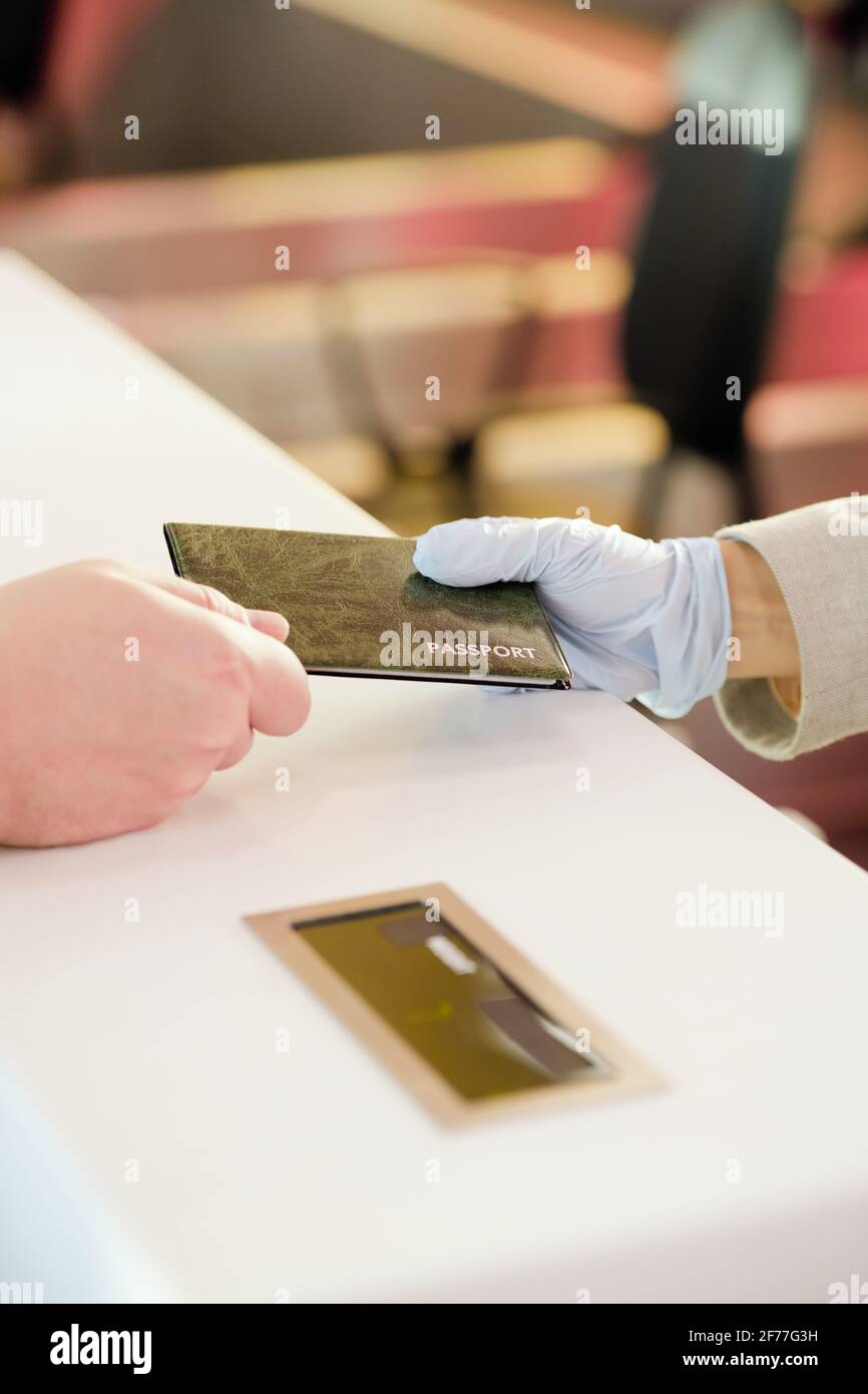 Gloved hand of female receptionist standing by counter and giving back ...