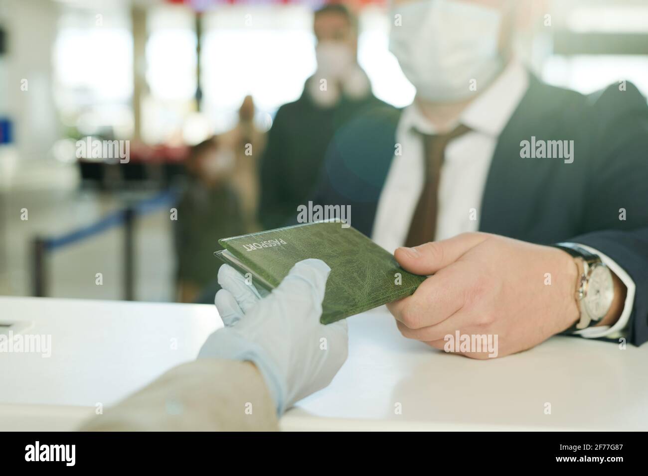 Gloved hand of female receptionist giving back passport of elegant ...