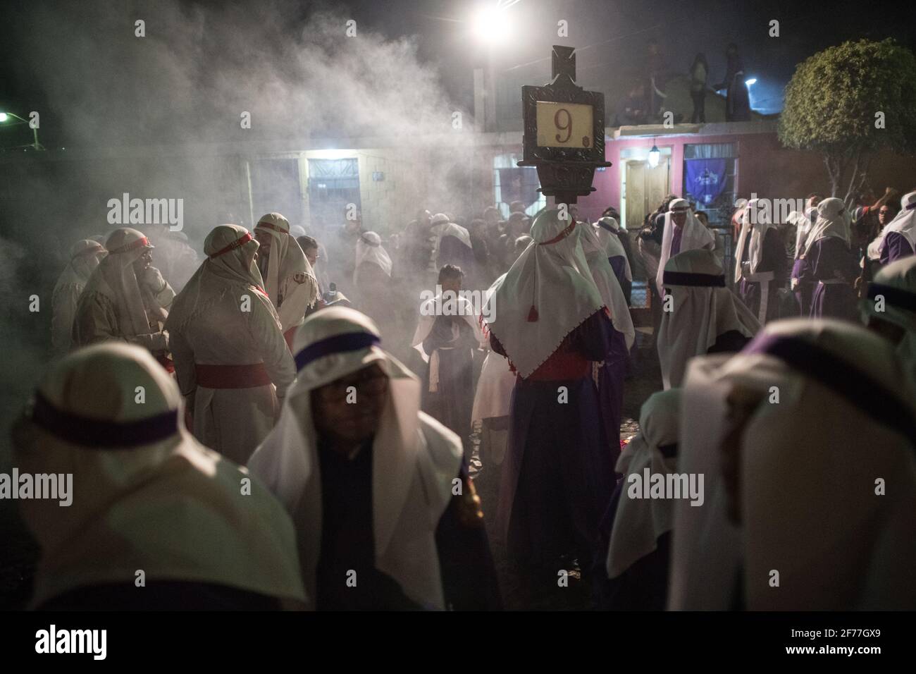 Cucuruchos in purple robes process solemnly through the streets of ...