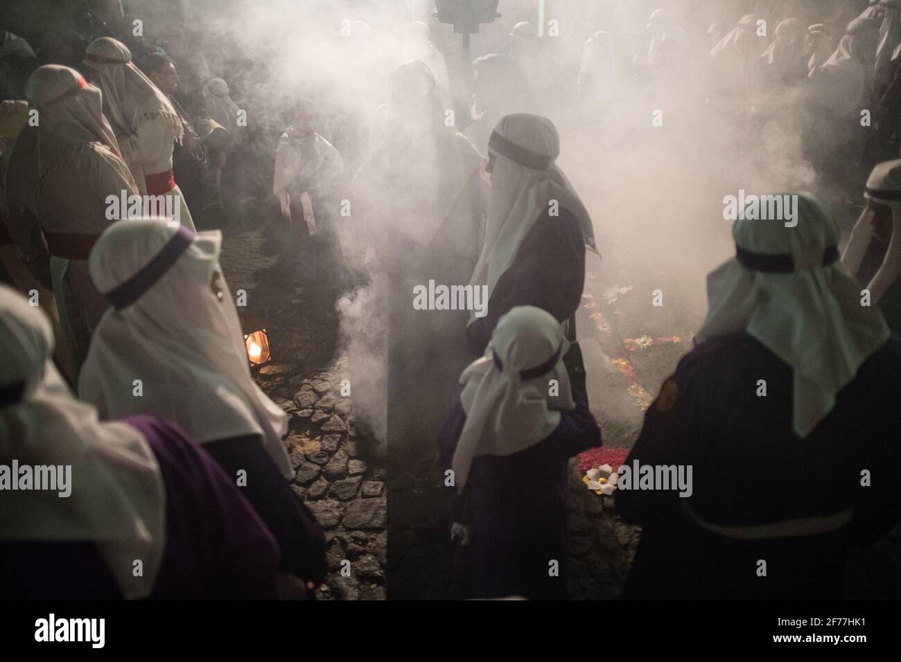 Cucuruchos in purple robes process solemnly through the streets of ...
