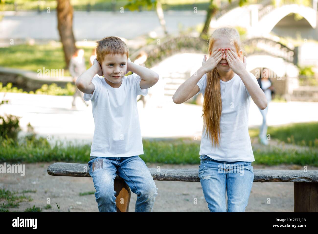 Cheerful children are playing in the park on a green bench Stock Photo ...
