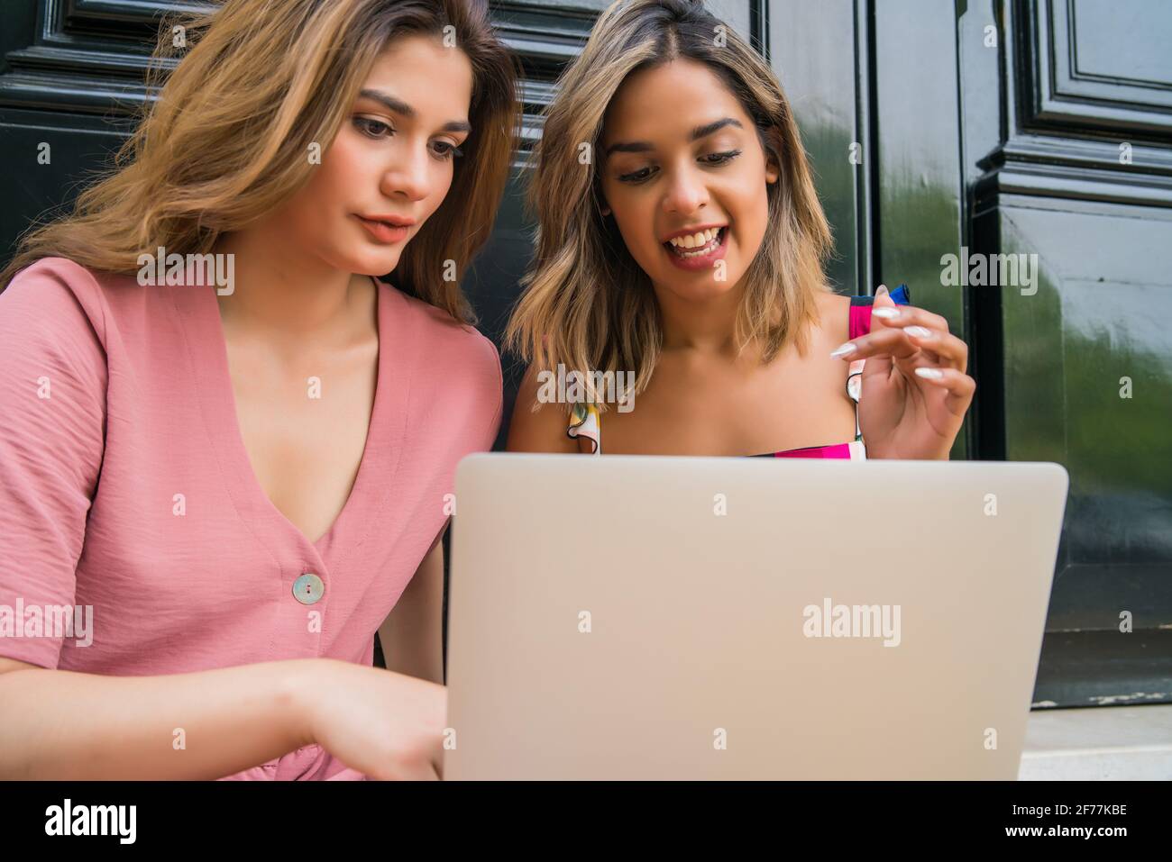 Two friends using laptop outdoors Stock Photo - Alamy