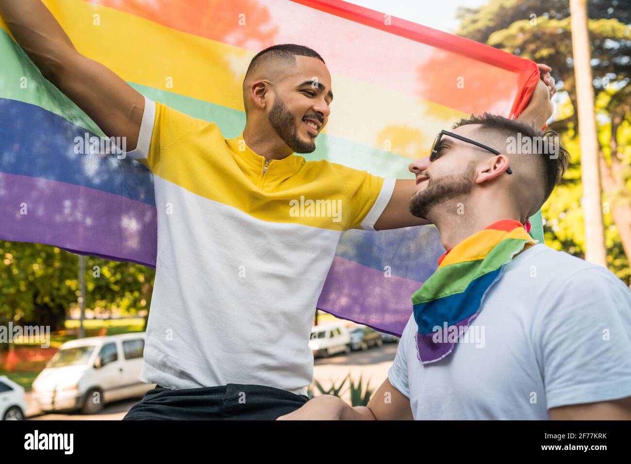 Gay couple embracing and showing their love with rainbow flag Stock ...
