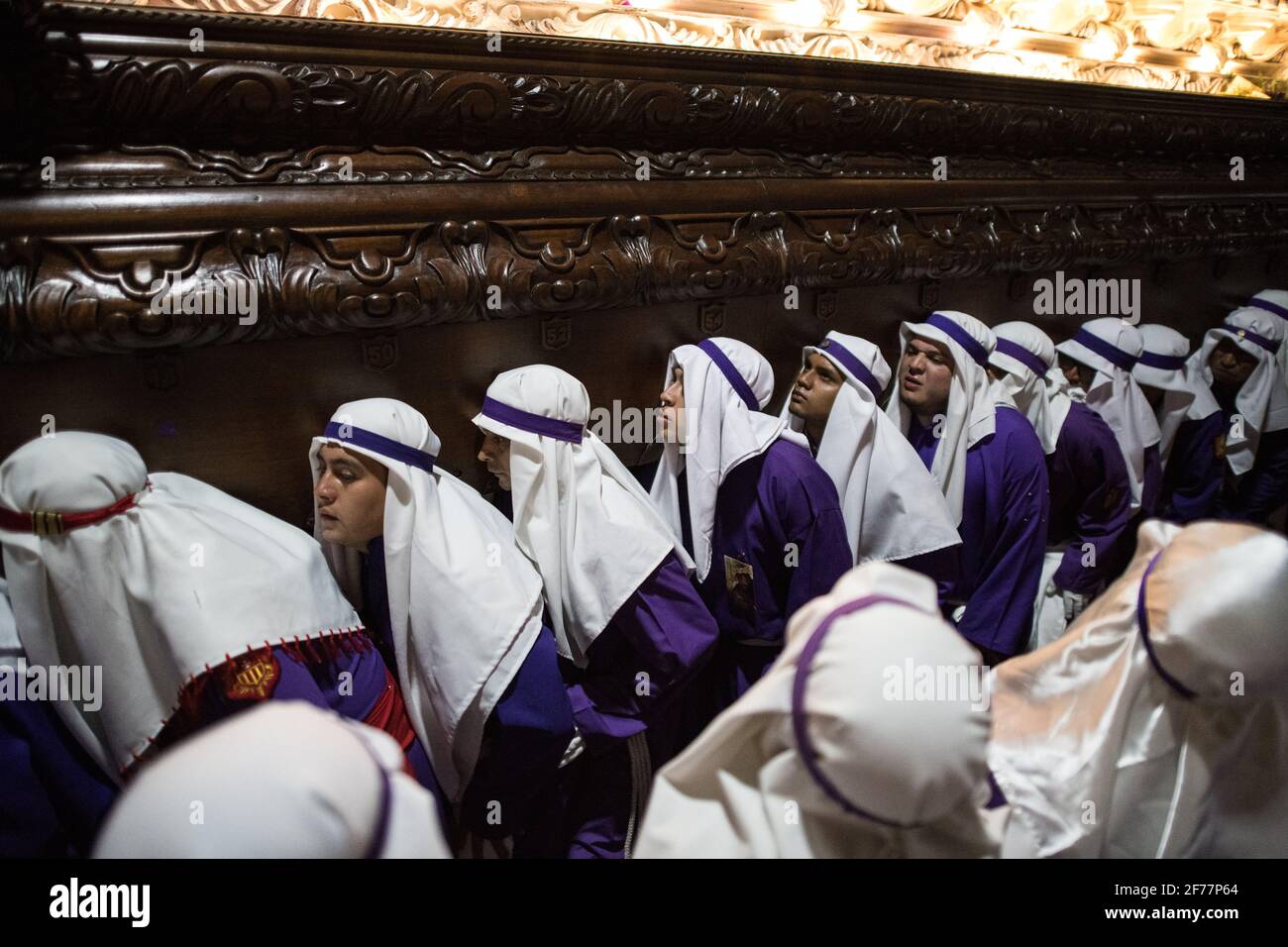 Cucuruchos in purple robes process solemnly through the streets of ...