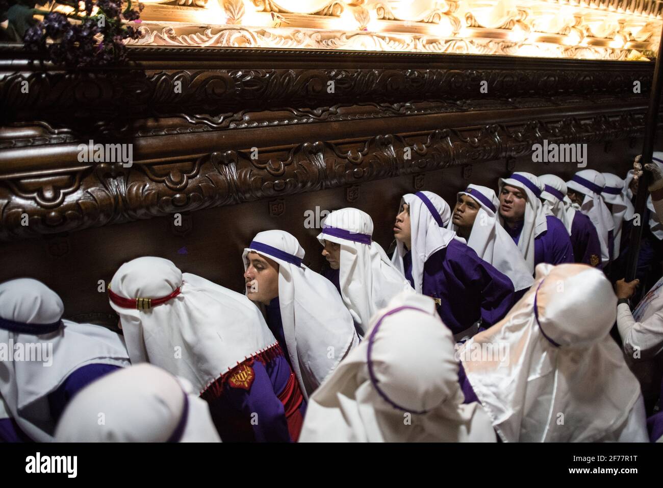 Cucuruchos in purple robes process solemnly through the streets of ...